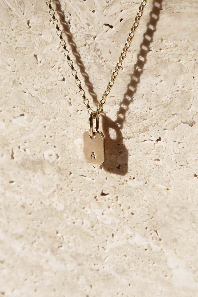 THE LOVE TAG LETTER GOLD NECKLACE – AURUM + GREY